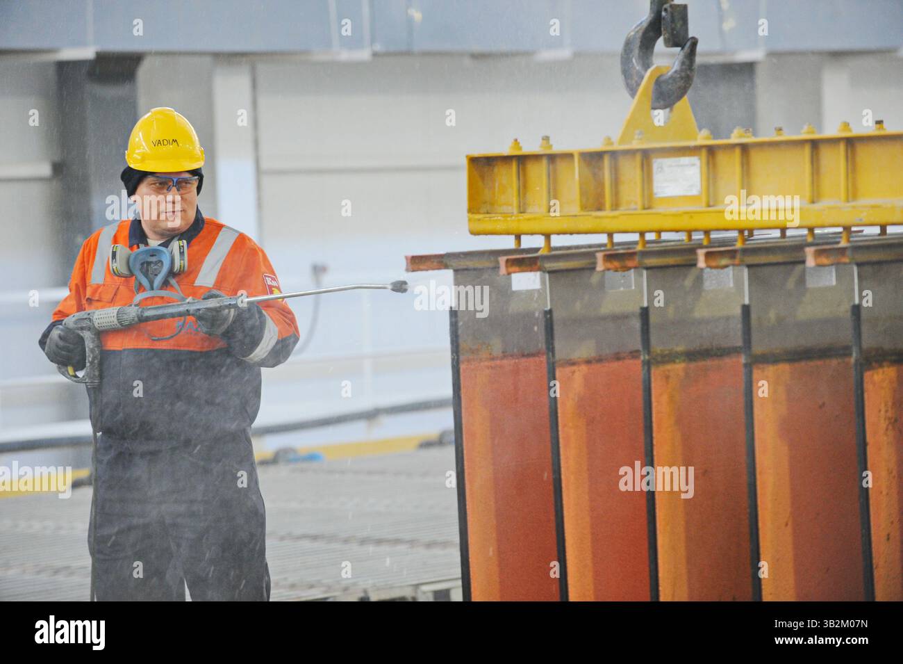 A worker washes plates with cathode copper at an industrial plant Stock ...
