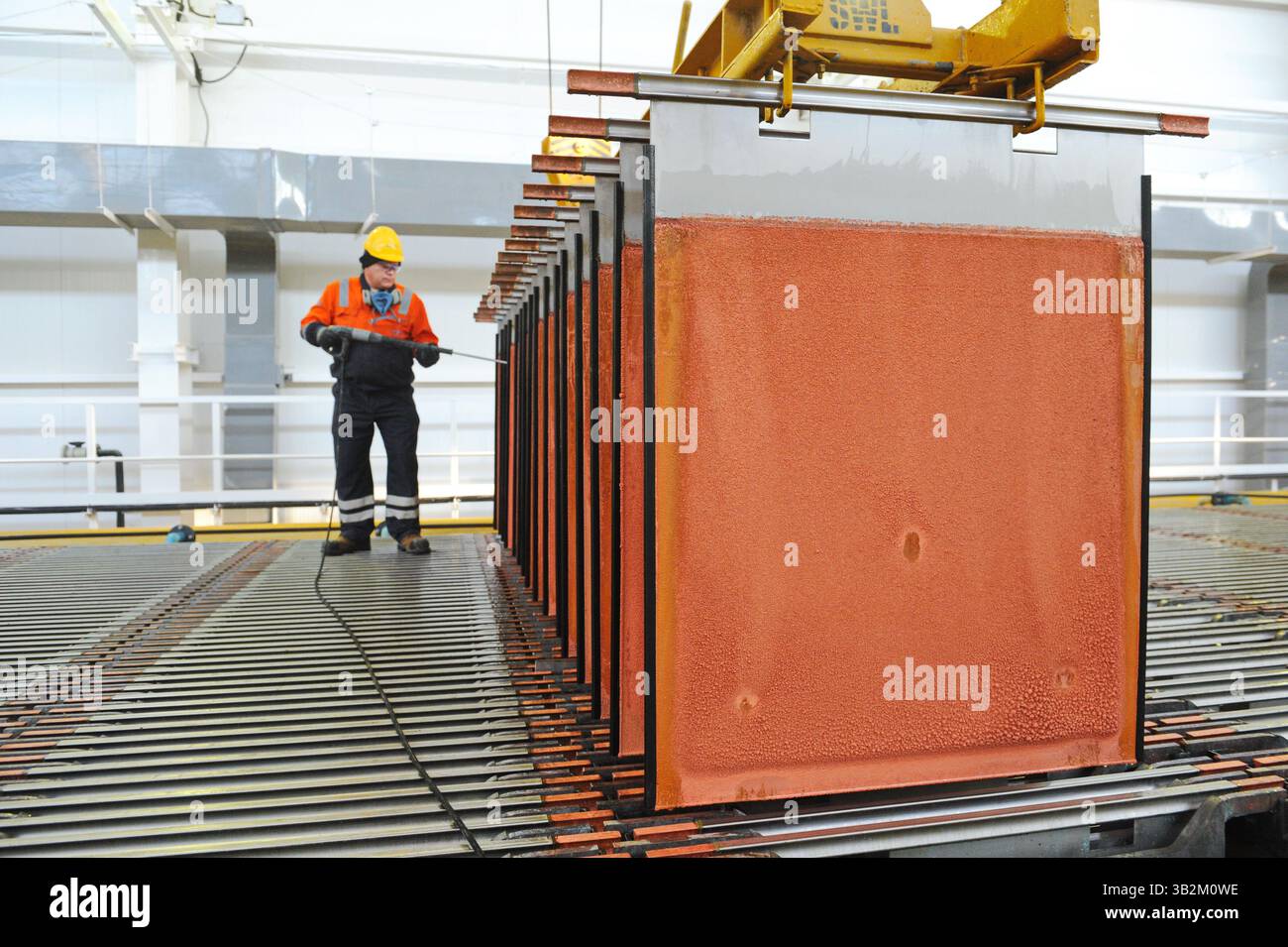 A worker washes plates with cathode copper at an industrial plant Stock ...