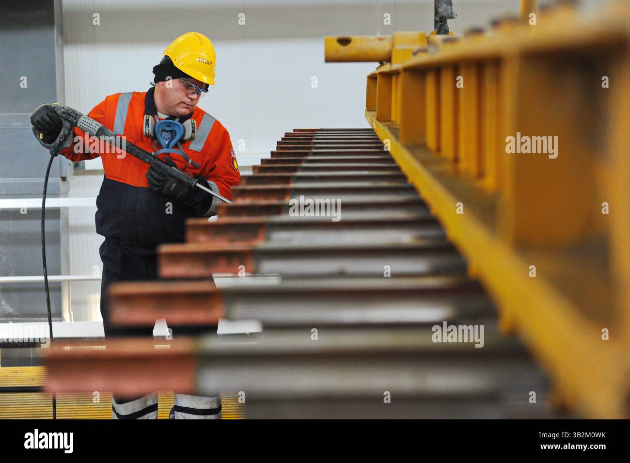 A worker washes plates with cathode copper at an industrial plant Stock ...