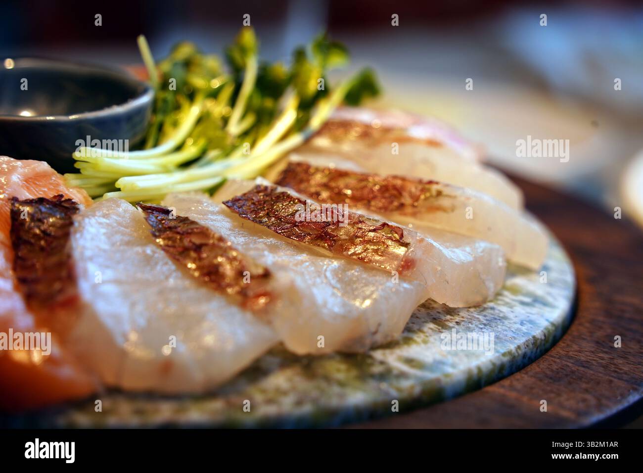 A beautifully arranged plate of fresh sashimi with garnishes Stock ...