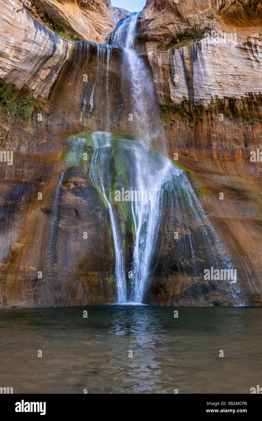 Water flows gracefully over a towering cliff, creating a stunning ...