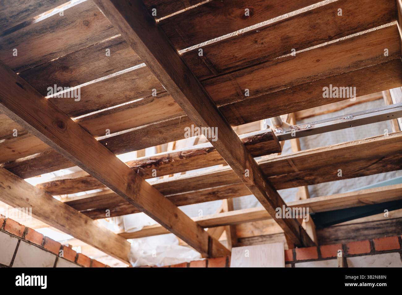 Wooden planks are installed on a ceiling at a construction site ...
