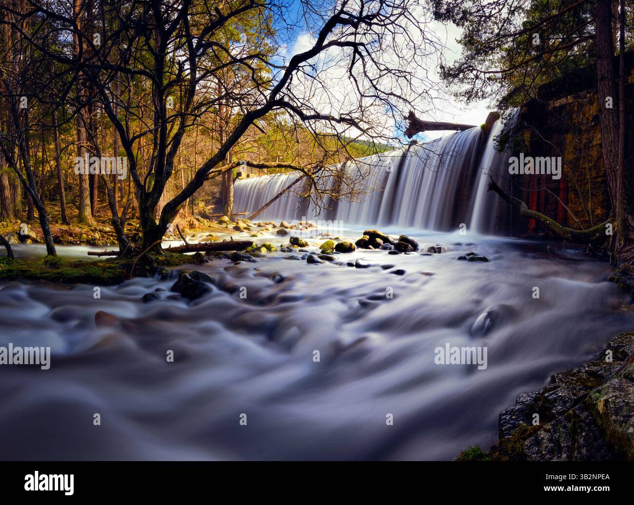 Waterfall of a high mountain dam in the middle of a forest Stock Photo ...