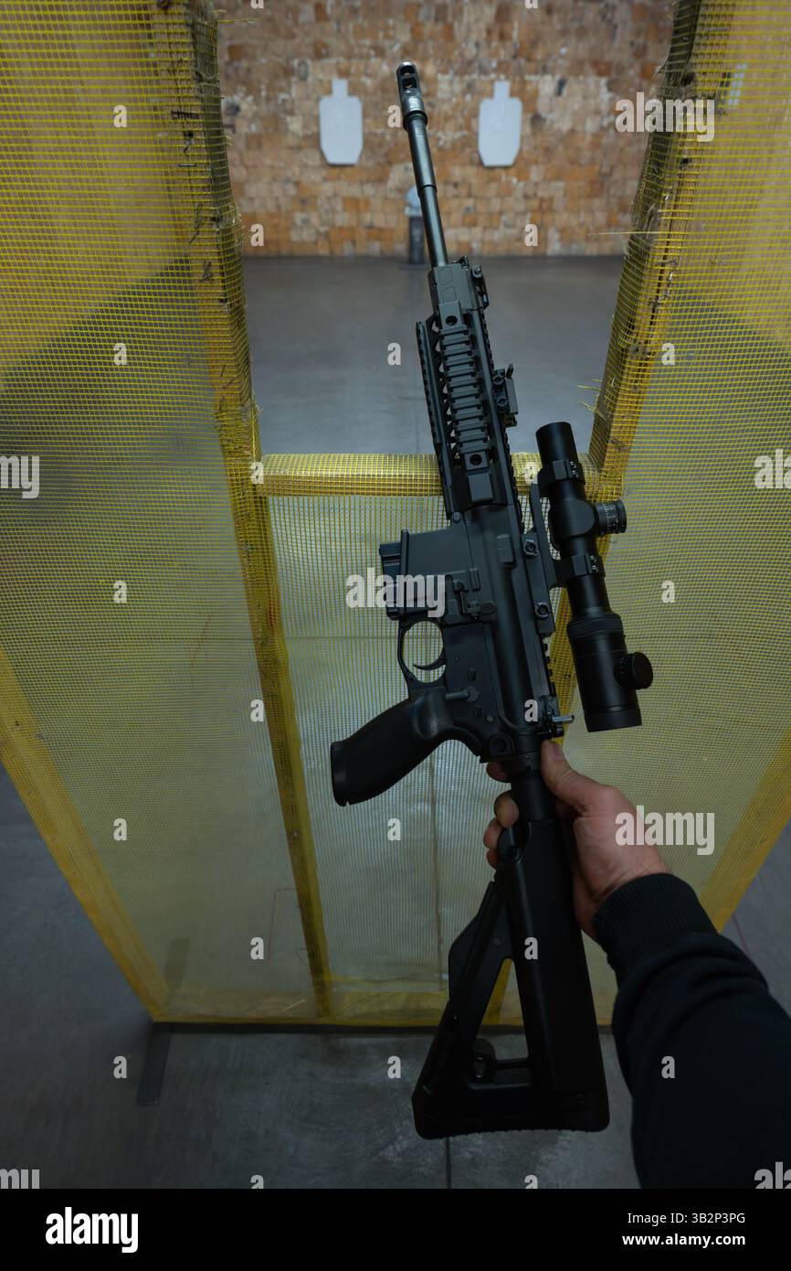Shooter holding a semi-automatic rifle with an optical sight at a ...