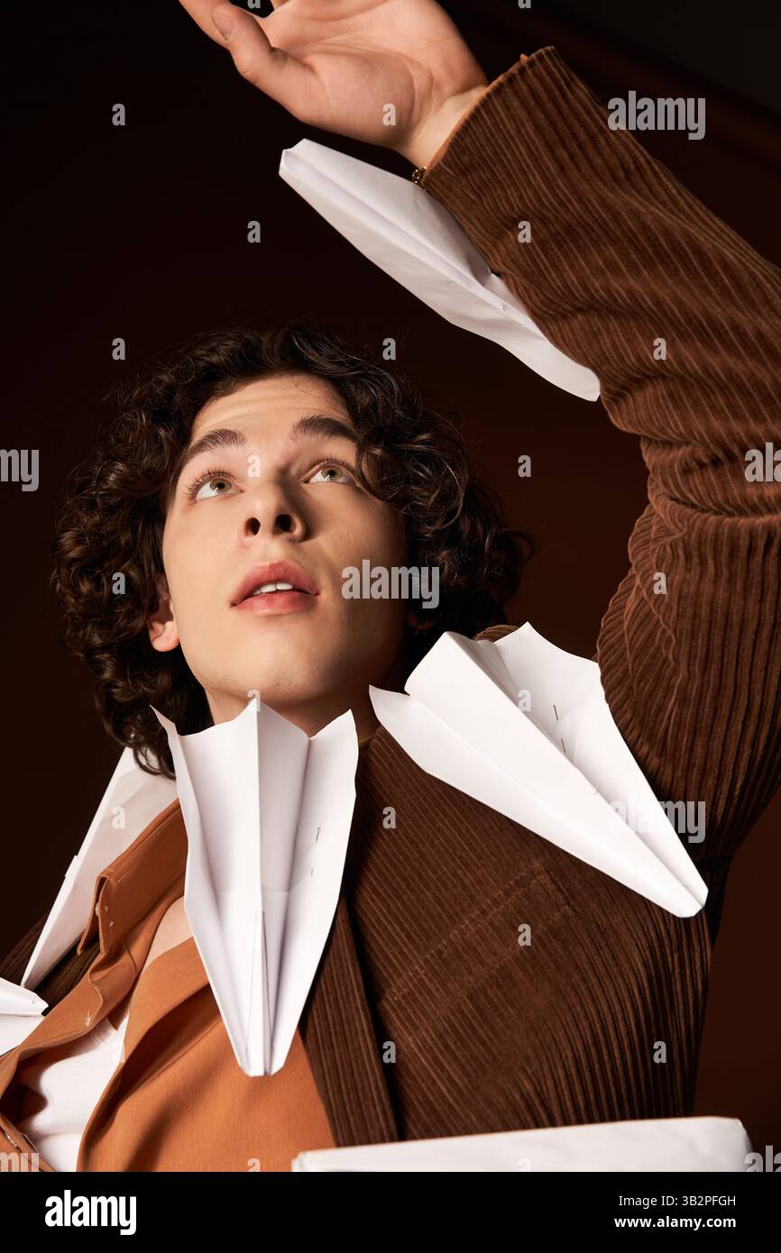 Curly-haired young man showcases a unique fashion statement with paper ...