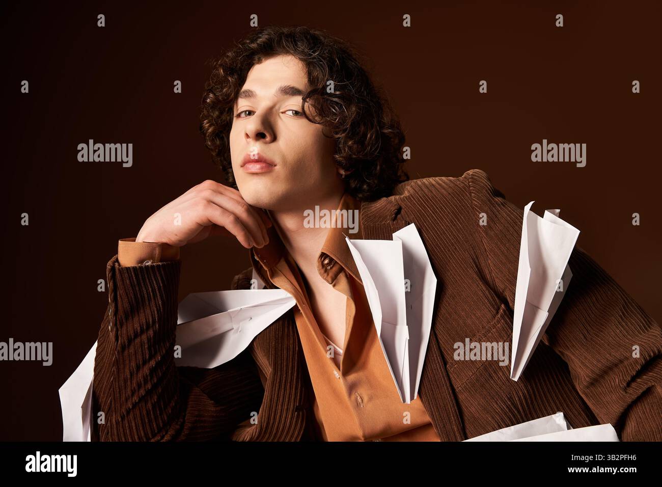 A good looking young man shows off his stylish outfit adorned with ...