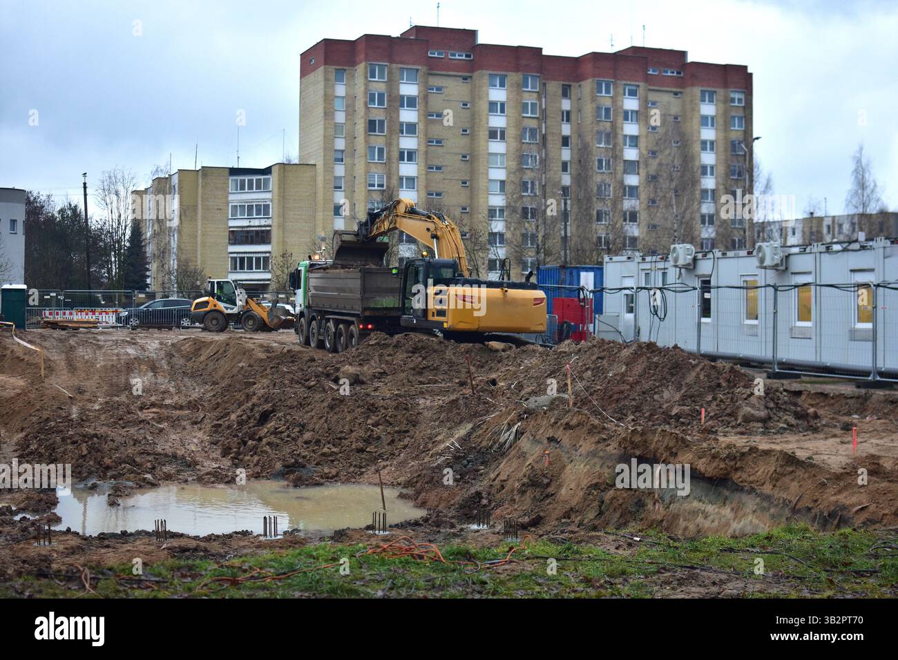 Excavator digging sand in dump truck in big construction site Stock ...