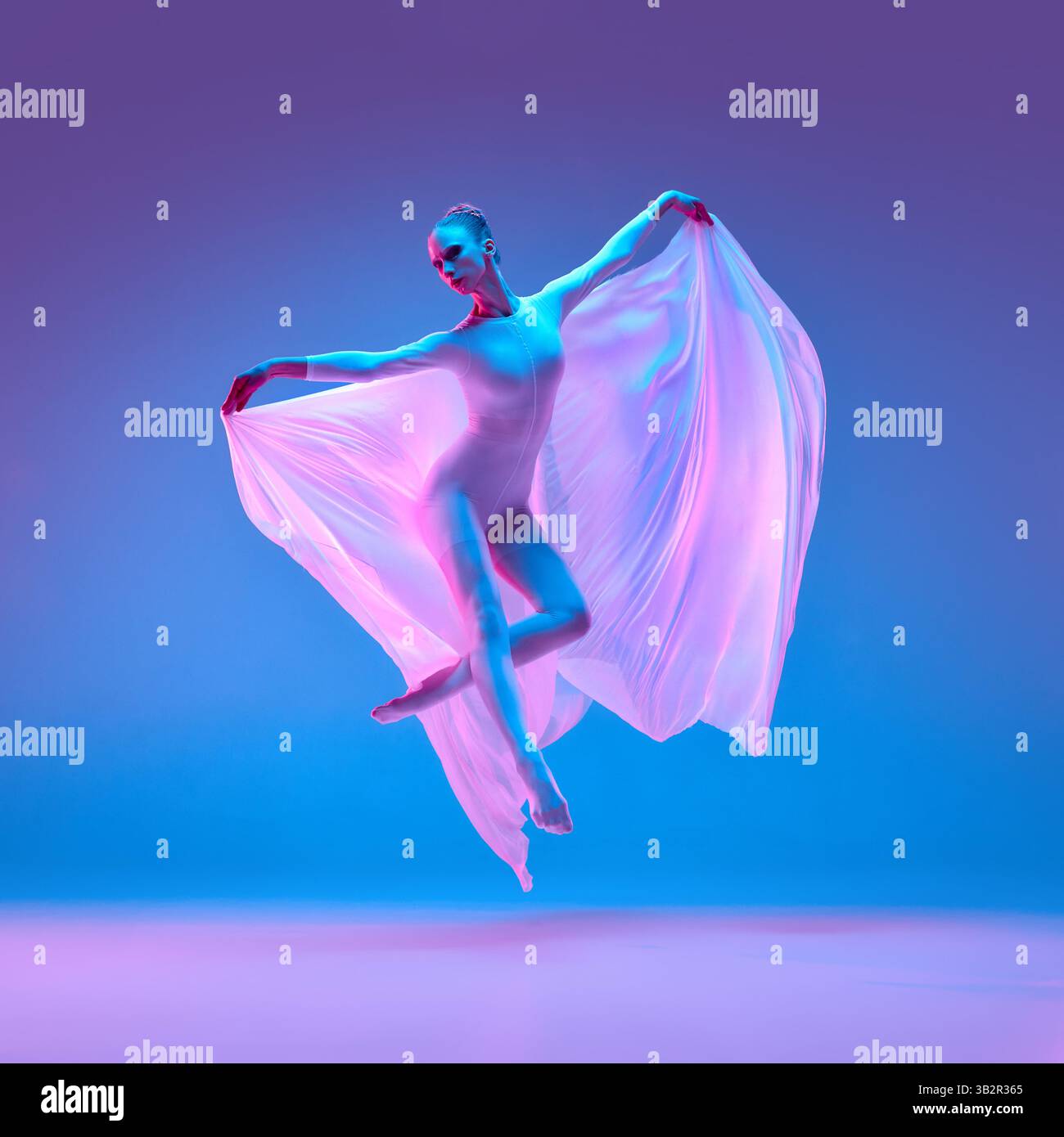 Dynamic photo of ballerina dancing midair holding wide-stretched veil ...