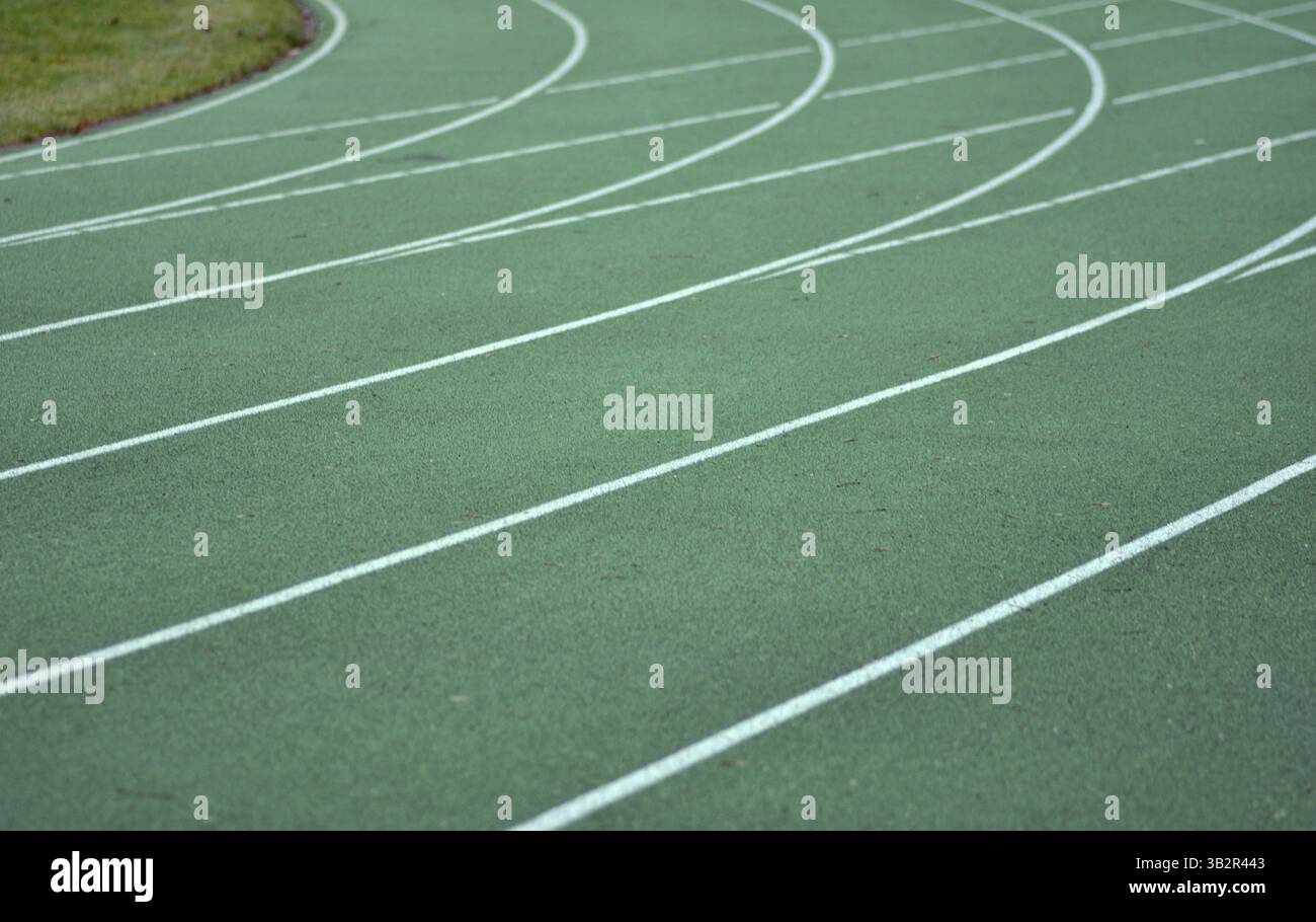 Green running track with white lines. Footpath in right side and green ...