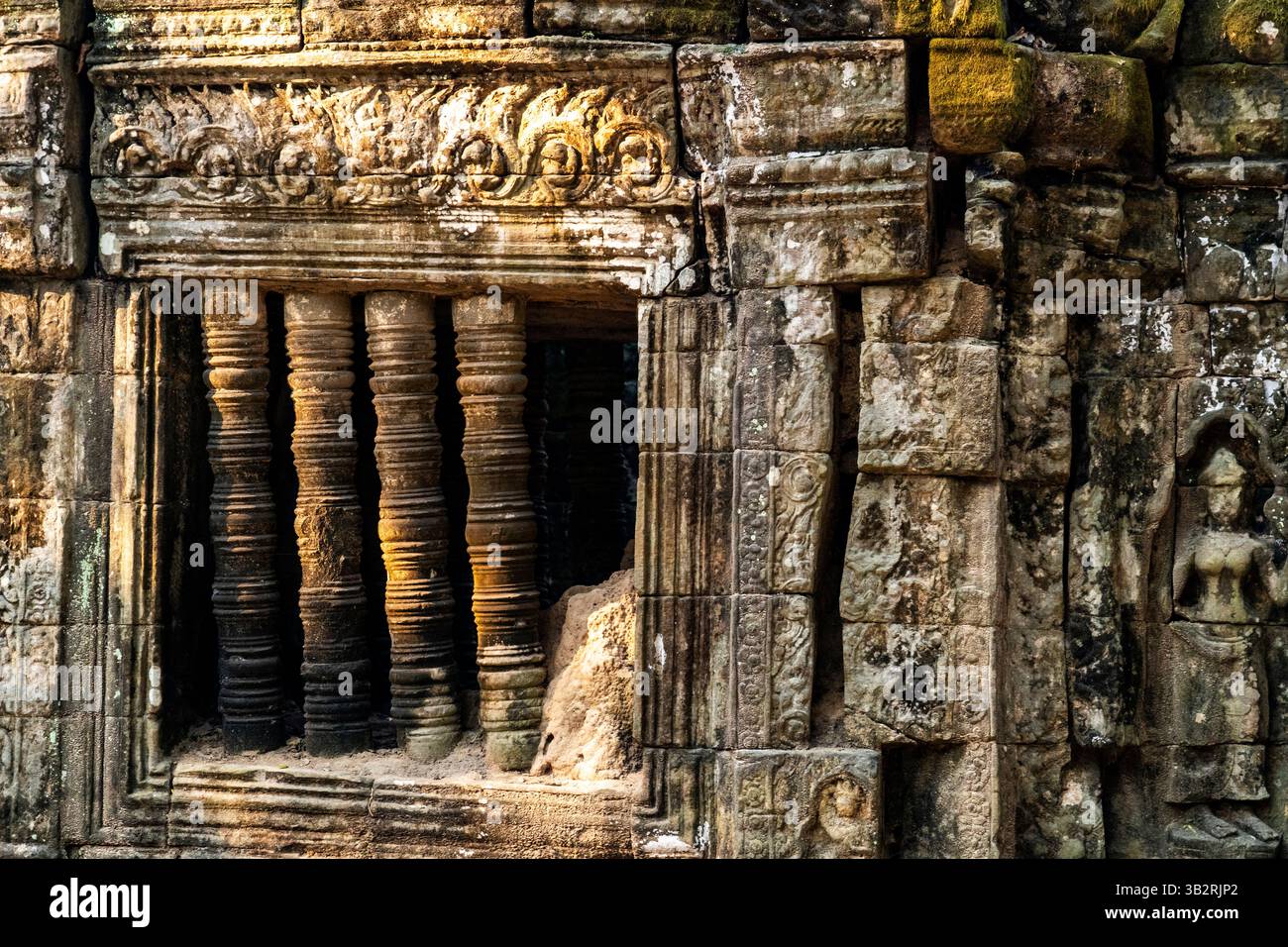 An ancient stone wall featuring intricately carved pillars and ...