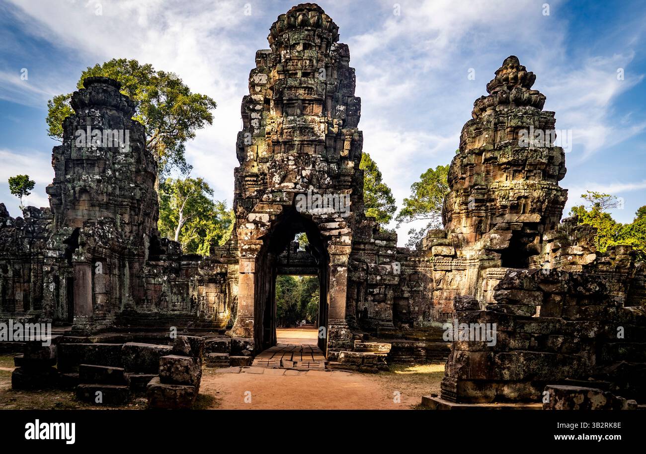 Ancient stone temple ruins surrounded by lush greenery under a blue sky ...