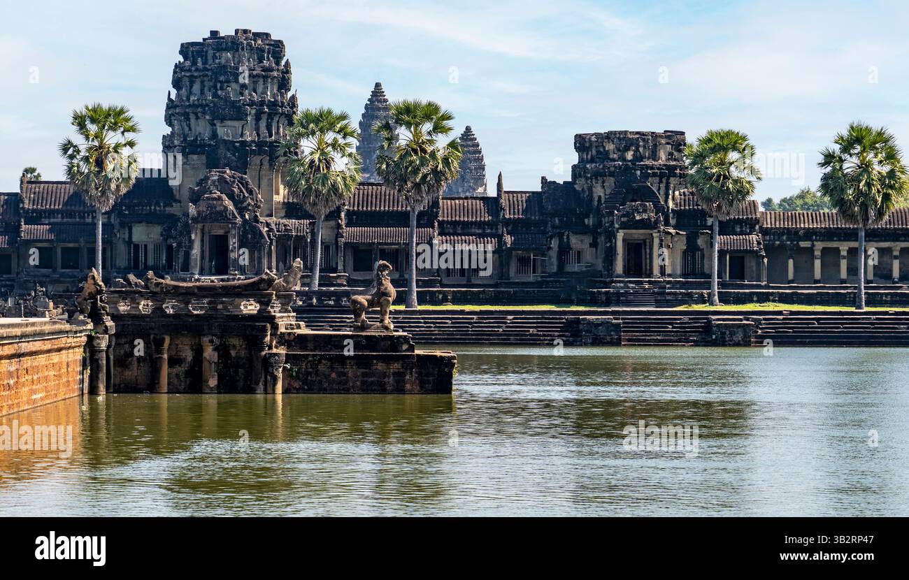 A serene view of ancient temple ruins surrounded by water and palm ...