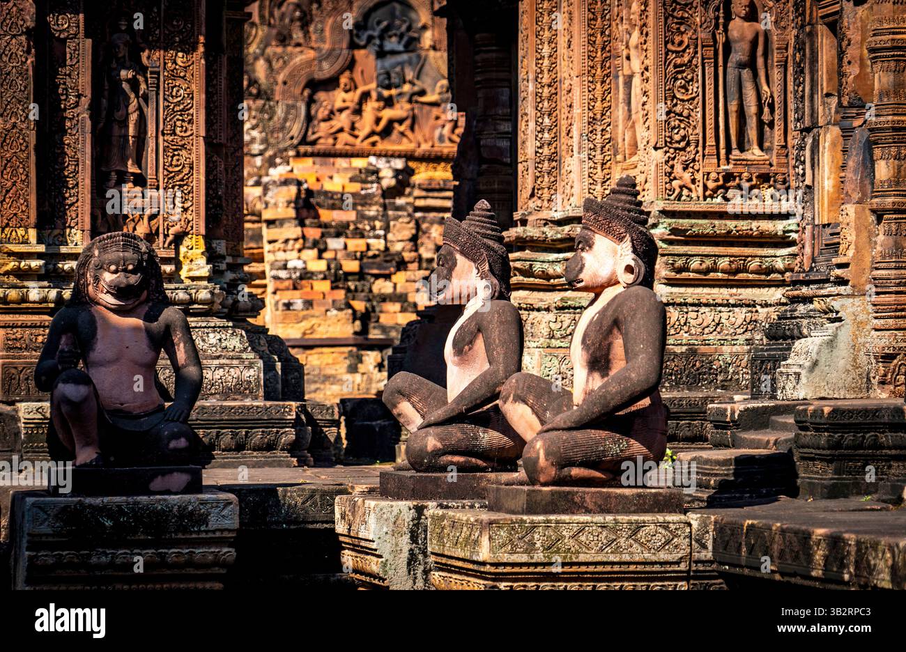 Ancient stone sculptures of seated figures and a monkey, set against ...