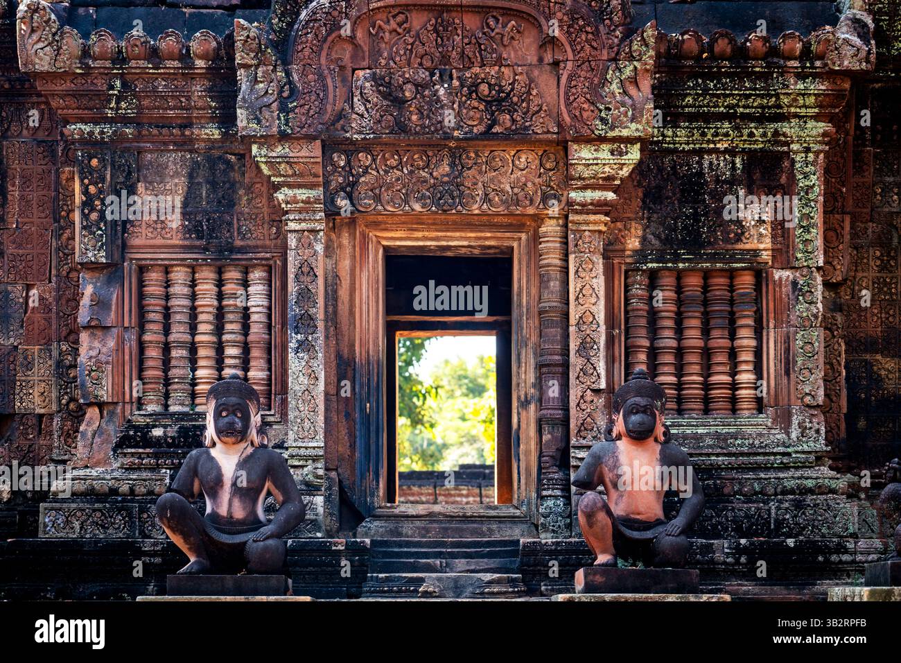 Ancient temple entrance with intricate carvings, flanked by two seated ...
