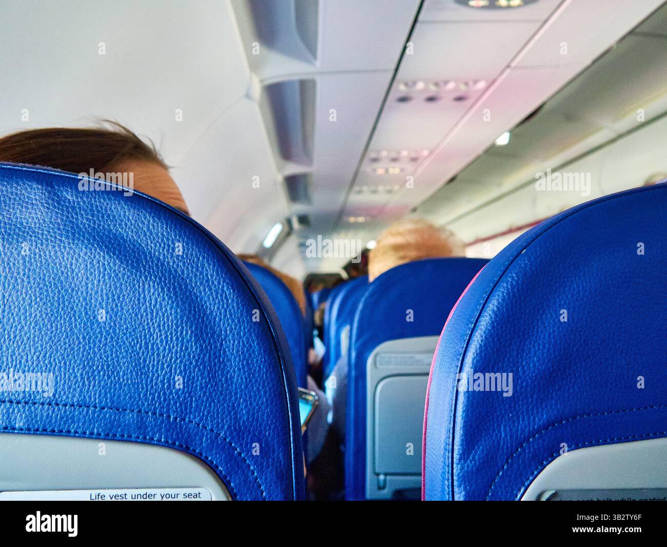 Interior of airplane with passengers on seats Stock Photo - Alamy
