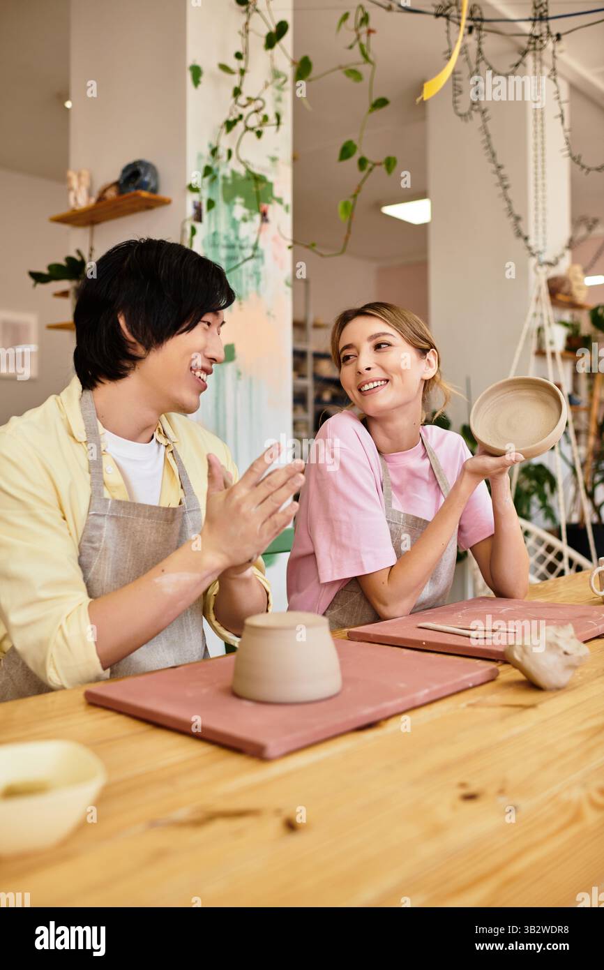Joyful young couple enjoys making pottery together, embracing ...