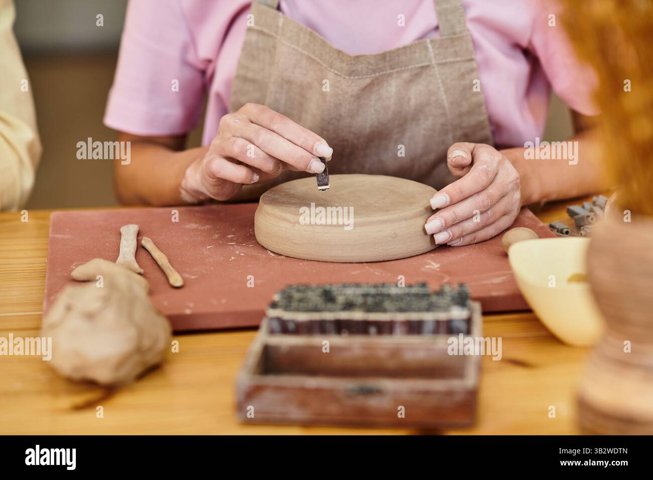 Hands shape clay into stunning art pieces in a lively pottery studio ...
