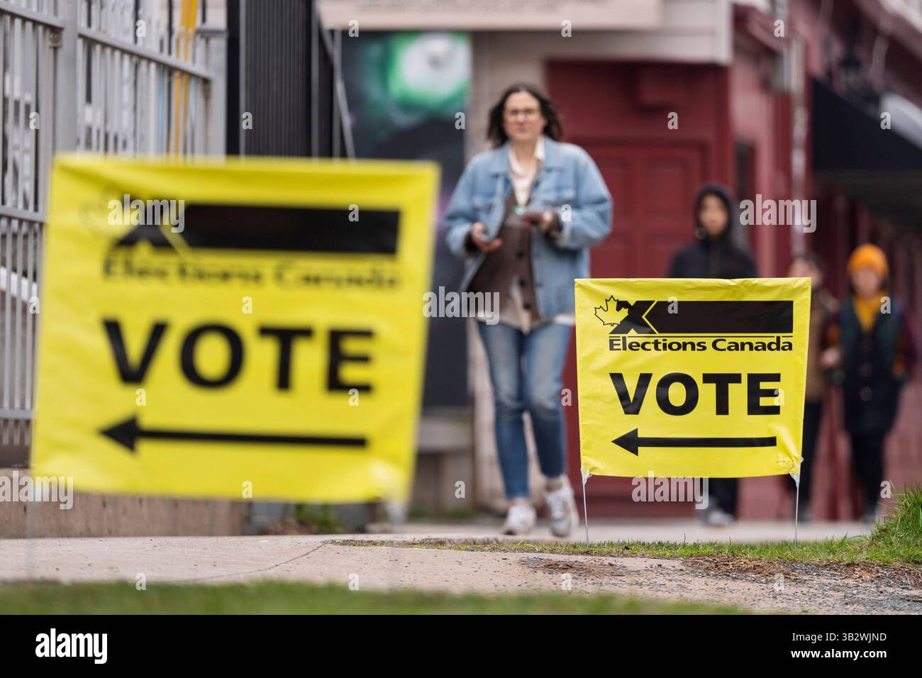 Elections Canada signage is seen as voters arrive at a polling station ...