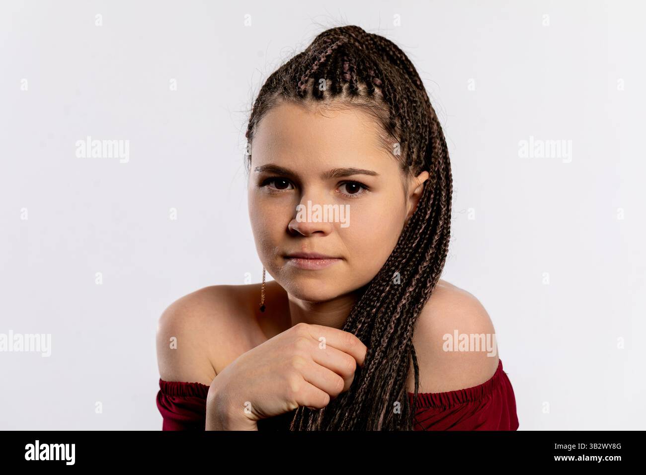 A confident young woman sporting stylish braids poses elegantly for a ...