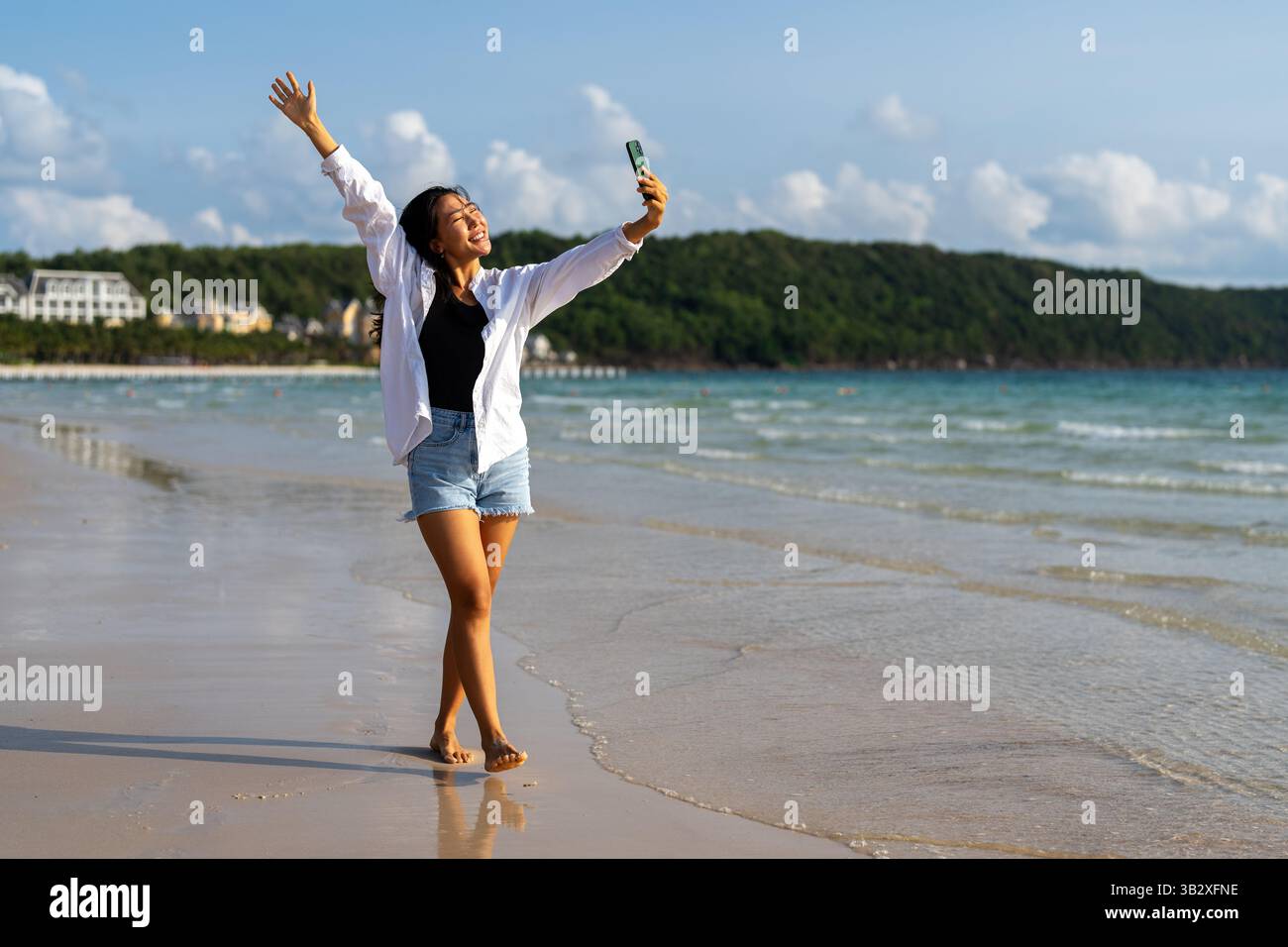 Influencer taking a selfie on a tropical beach, enjoying vacation ...