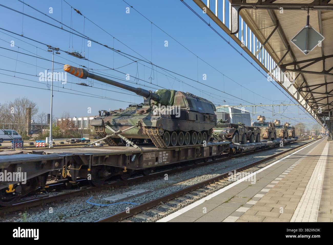 Military tanks and armored vehicles on freight train at railway station ...