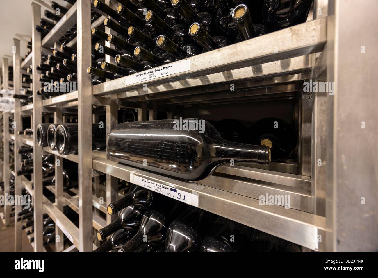 Large wine bottle lying down aging with other bottles standing up in ...