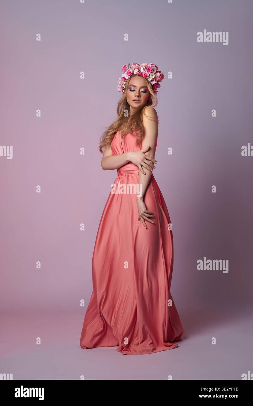 woman stands confidently in a flowing pink dress, complemented by a ...