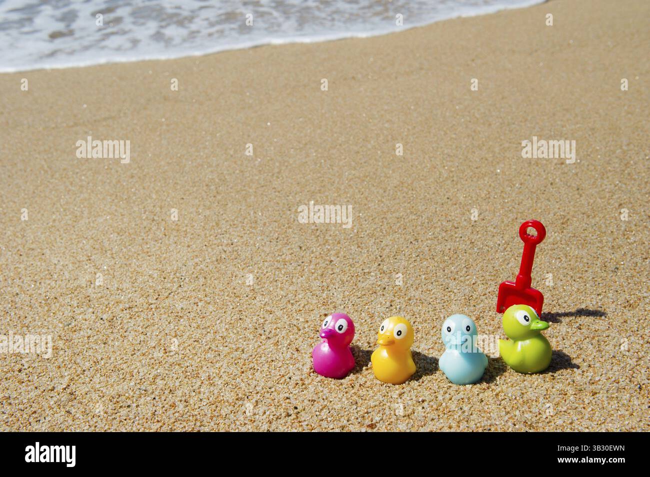 Colorful toy ducks in the sand at the beach Stock Photo - Alamy