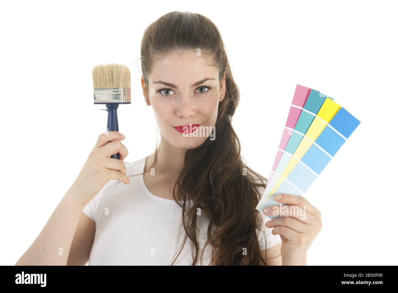 Portrait young female adult with paint brush and color samples isolated over white background ...