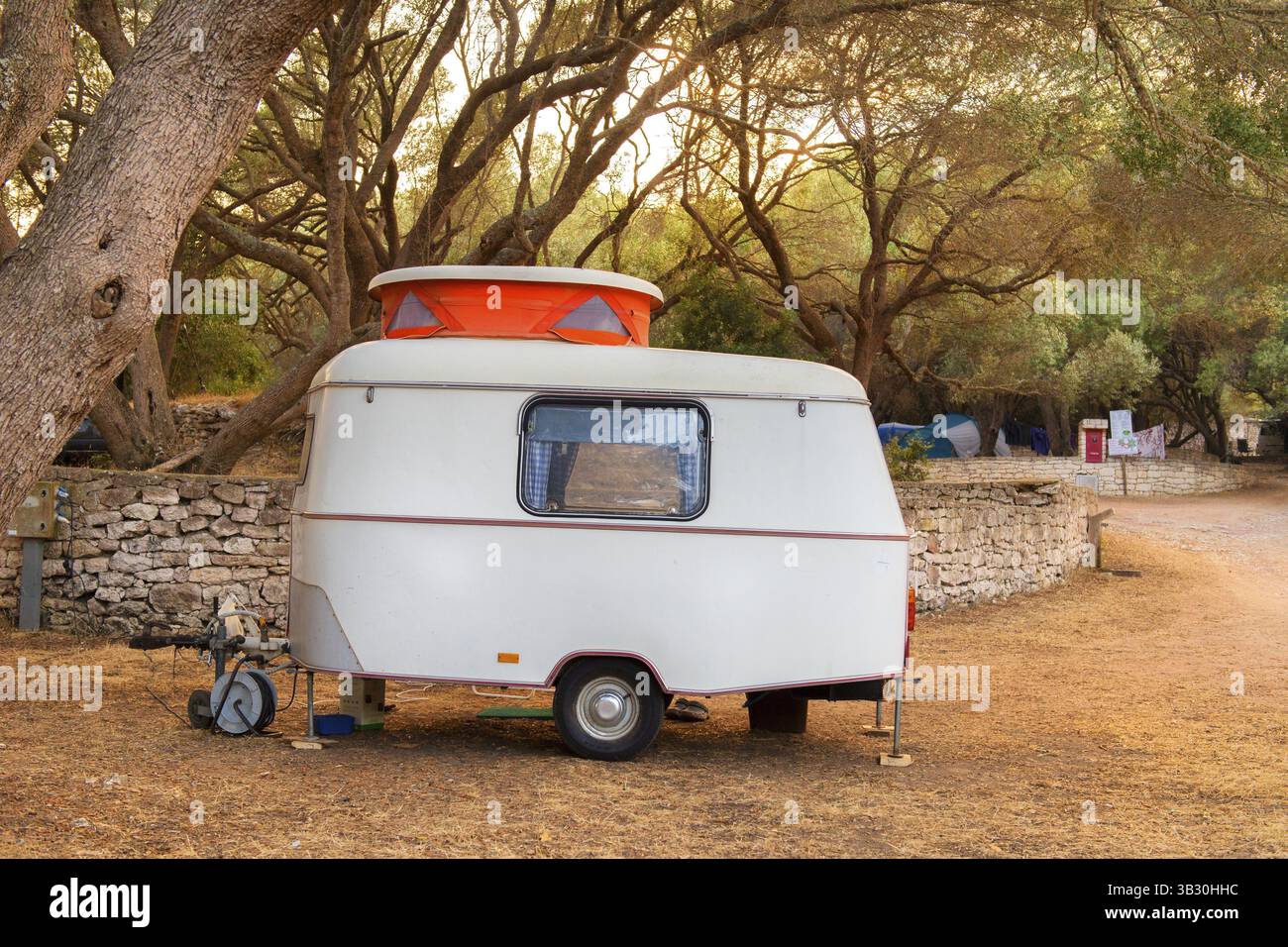 Tiny little caravan with orange sliding roof on camp ground Stock Photo ...