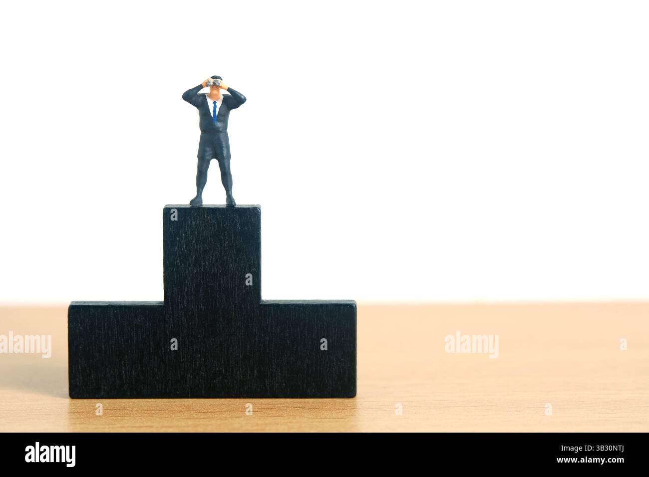 Businessmen standing using binoculars above black podium on desk ...