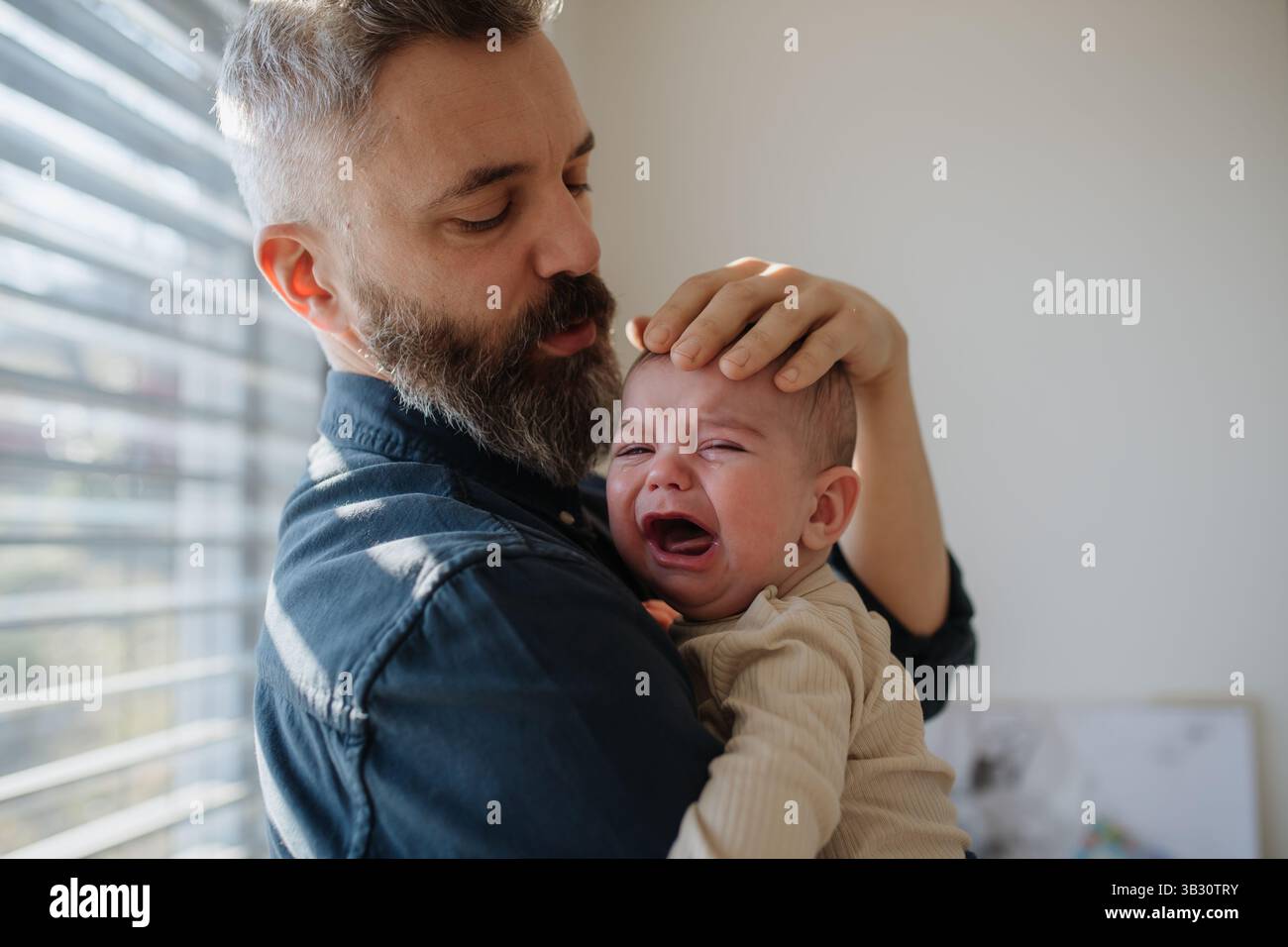 Father comforting his crying baby son Stock Photo - Alamy