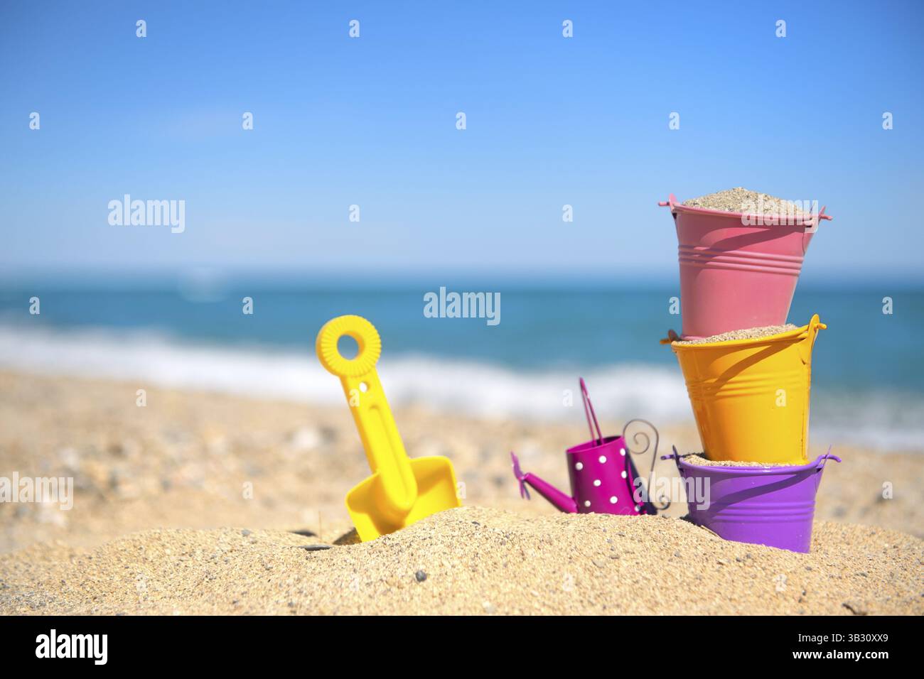 Colorful toy buckets at the beach Stock Photo - Alamy