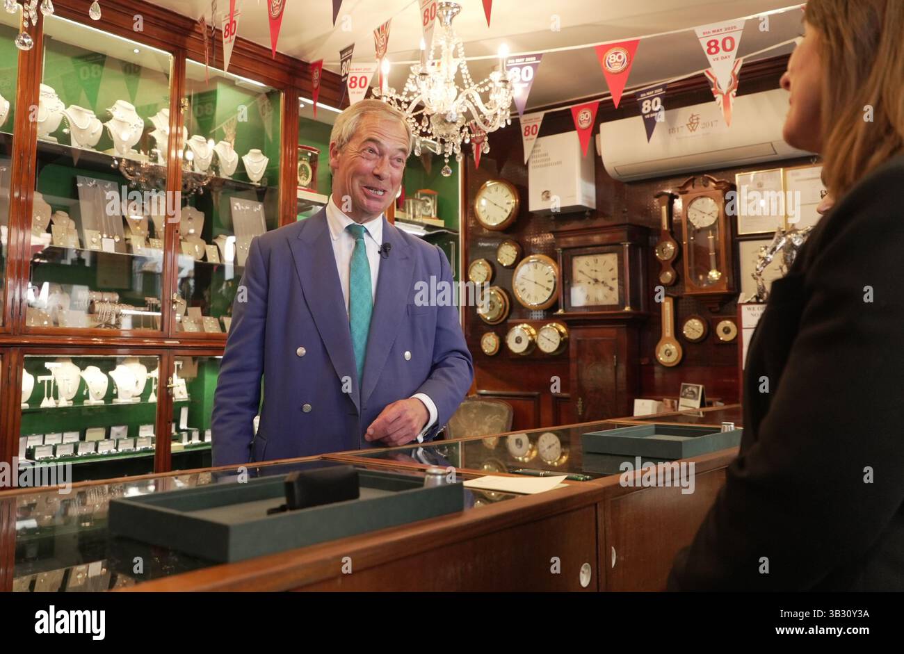 Reform UK leader Nigel Farage speaking to locals in a store in ...