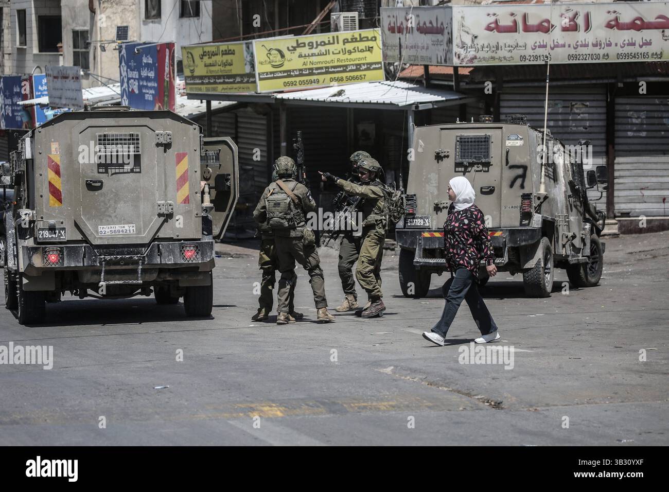 Nablus, Palestine. 28th Apr, 2025. A Palestinian woman walks past ...