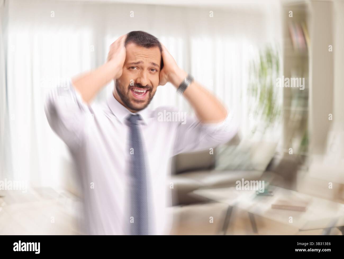 Man loosing his mind holding head and feeling dizzy Stock Photo - Alamy