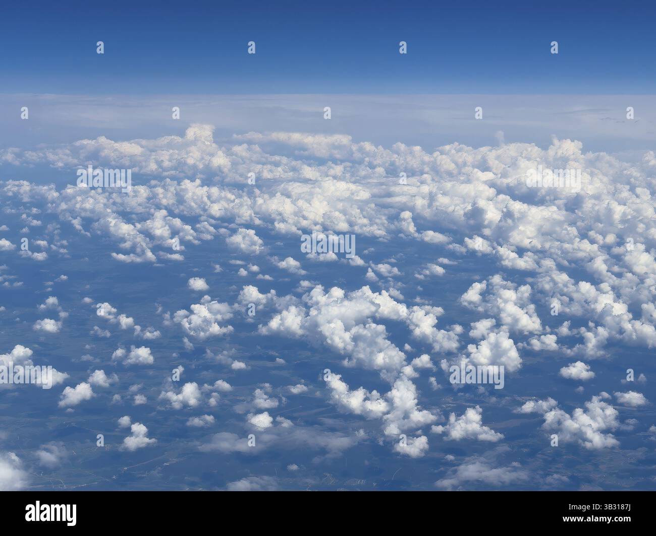 View from aeroplane at high altitude from above on large cloud field ...