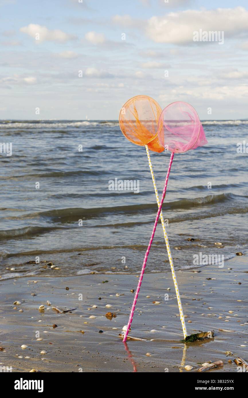 Colorful fishing nets at the beach near the water line Stock Photo - Alamy