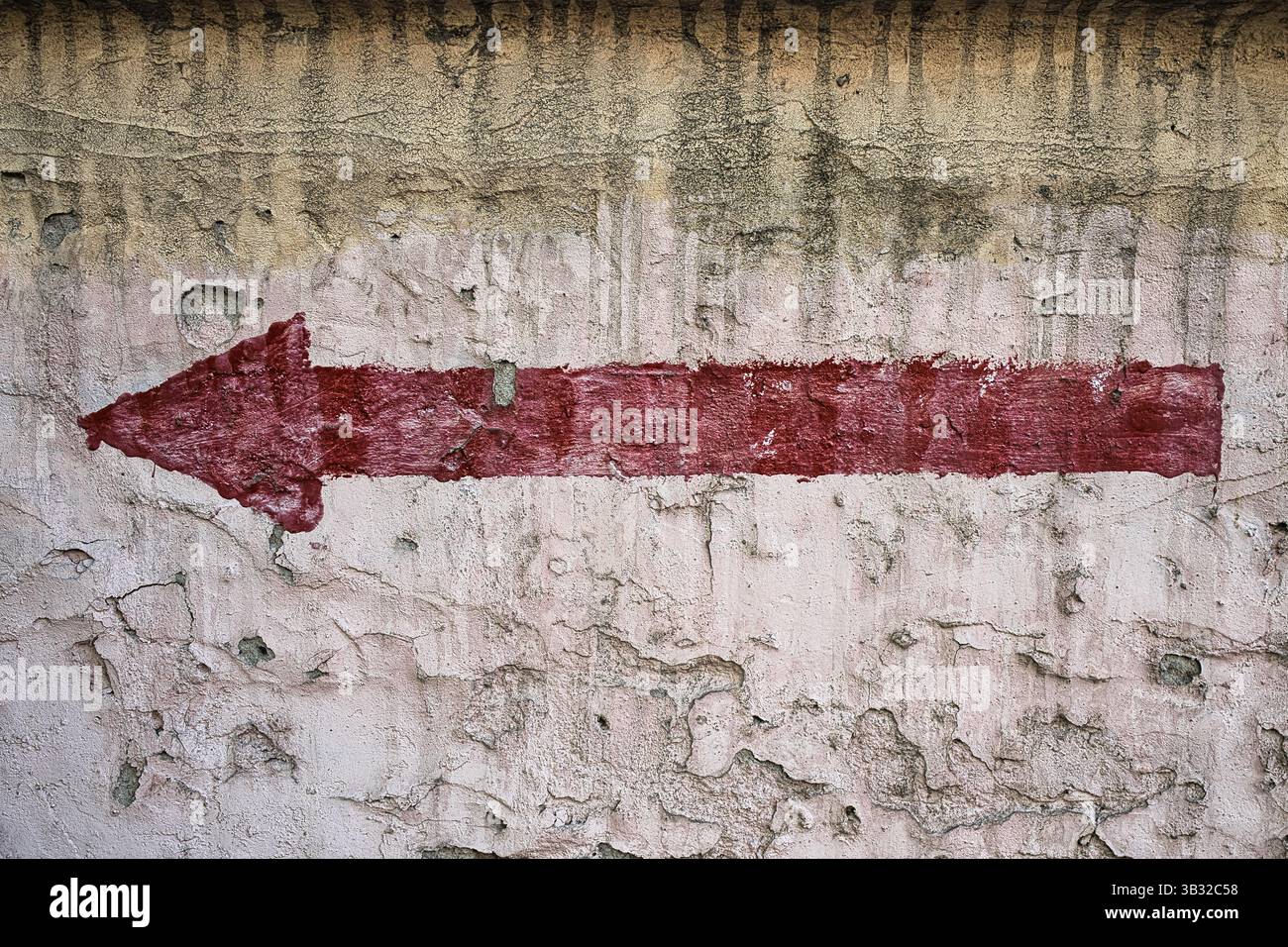 Red arrow pointing left, painted on an old abandoned wall Stock Photo ...