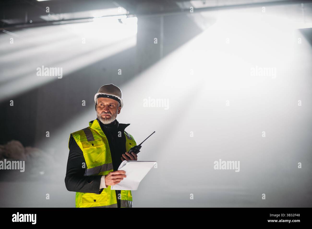 Construction foreman giving instructions over radio during building ...