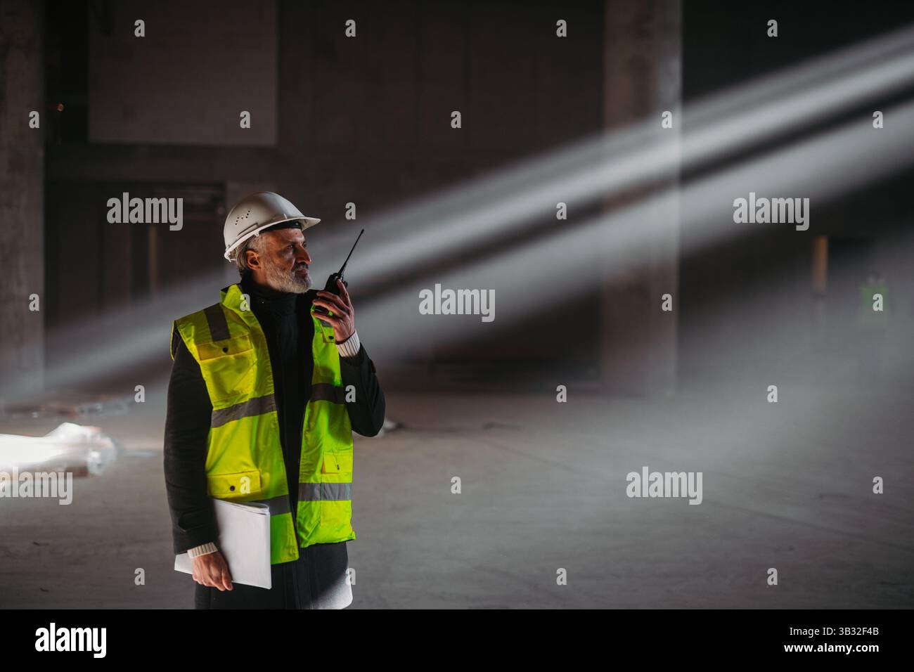 Construction foreman giving instructions over radio during building ...