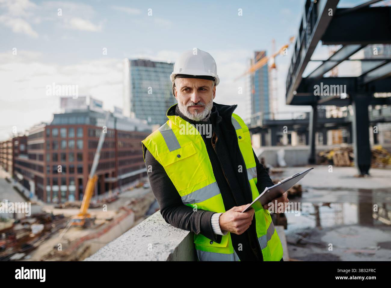 Engineer checking building documentation on clipboard at construction ...