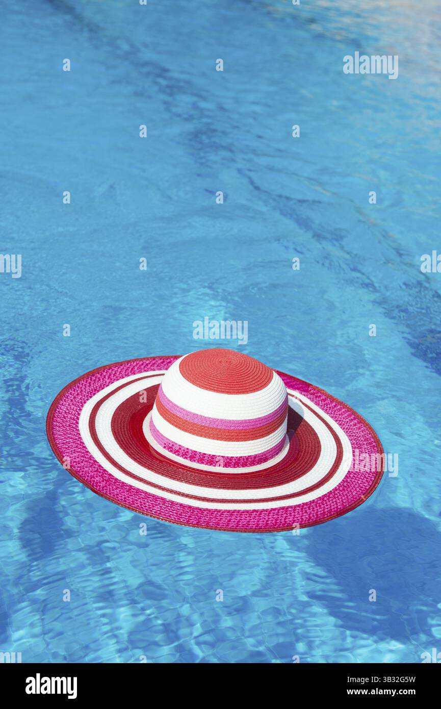 Luxury swimming pool with pink female sun hat Stock Photo - Alamy