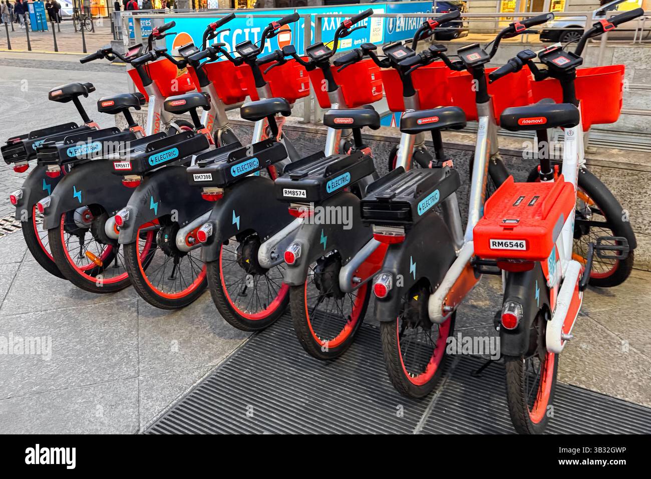 Milan, Italy - April, 12, 2025: Electric rental bikes parked at bike-sharing station near ...