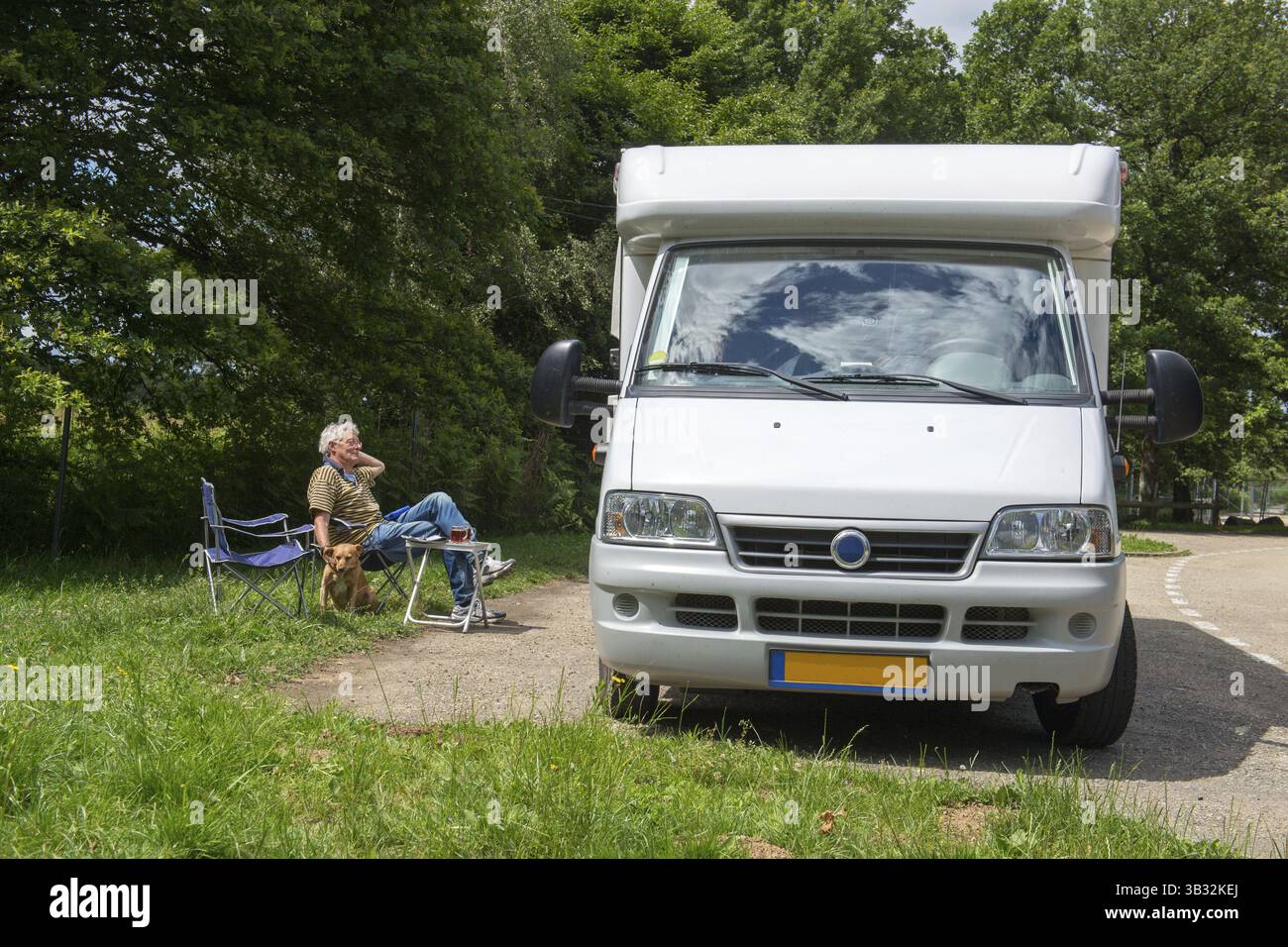Man sitting with dog having a break with mobil home Stock Photo - Alamy