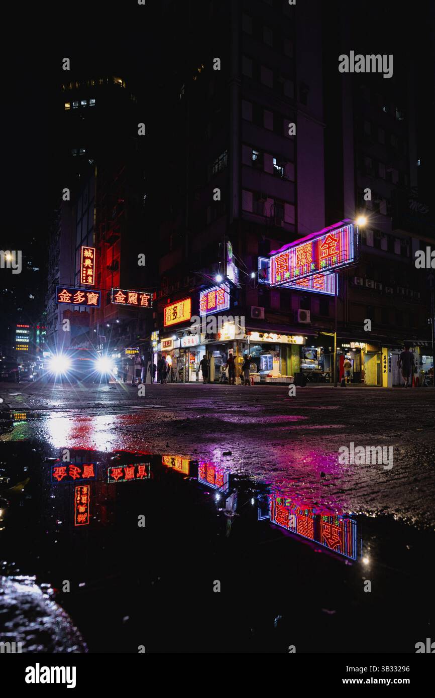 HONG KONG, CHINA - SEPTEMBER 28, 2024: Busy street corner at night with ...