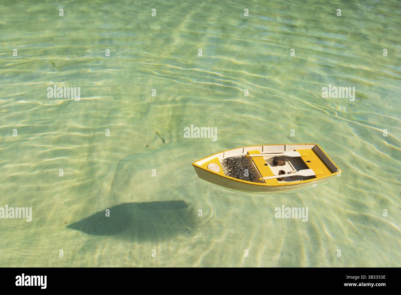Yellow rowing boat floating on water Stock Photo - Alamy