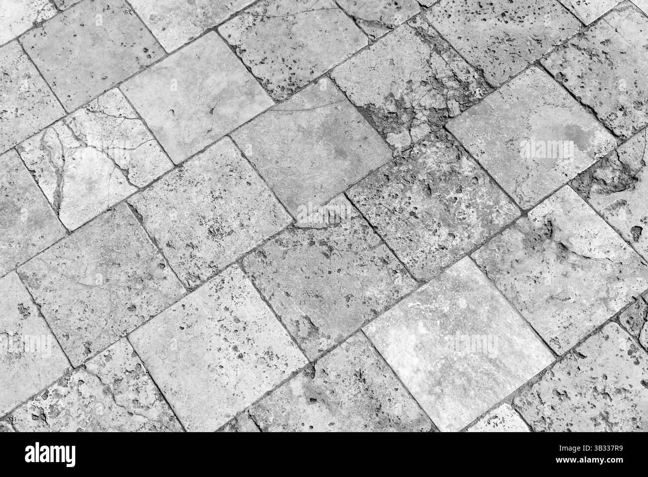 Rustic black and white image of square stone tiles with uneven texture ...