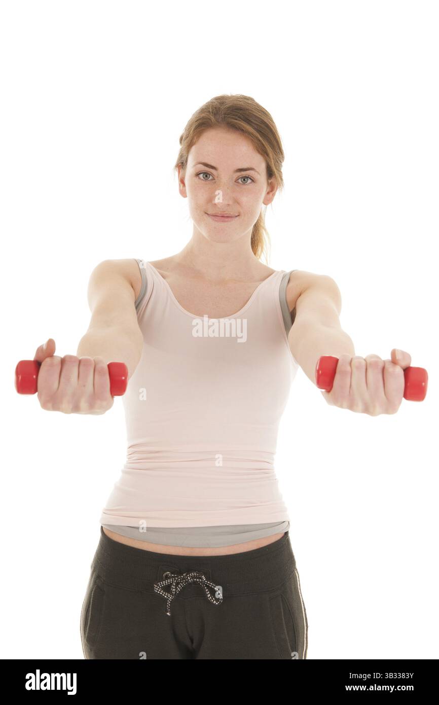 Slim young woman exercising with small dumbbells isolated over white ...