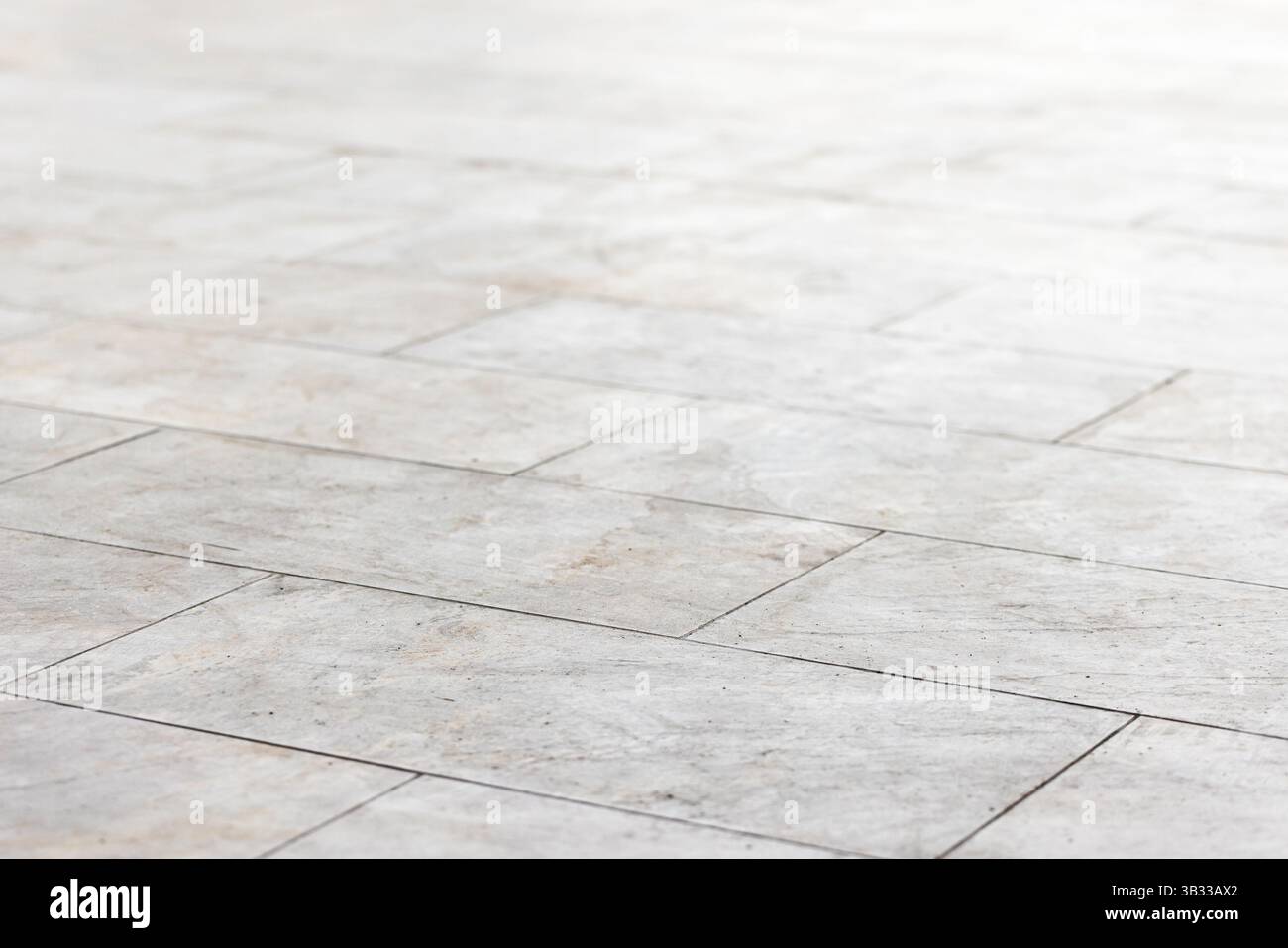 Tiled floor surface with a geometric layout, clean lines, and a bright ...